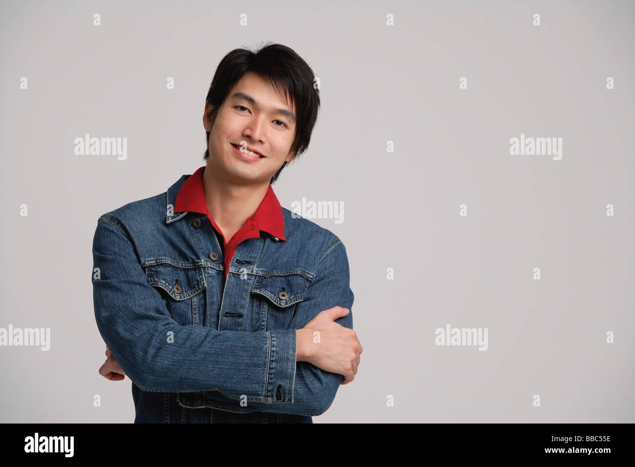 Man in denim jacket, arms crossed Stock Photo - Alamy
