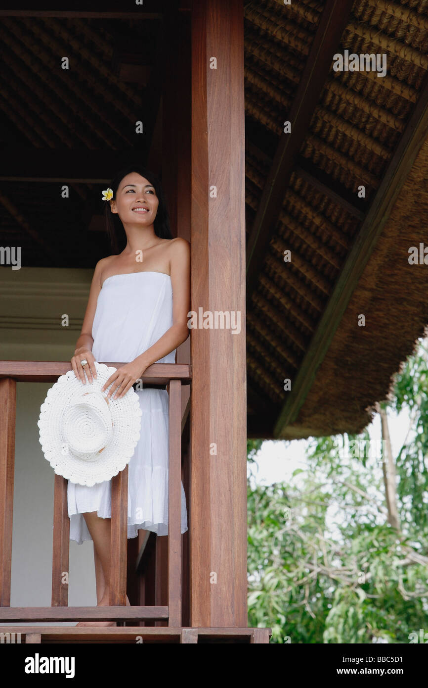 Young woman standing in balcony, looking away Stock Photo - Alamy