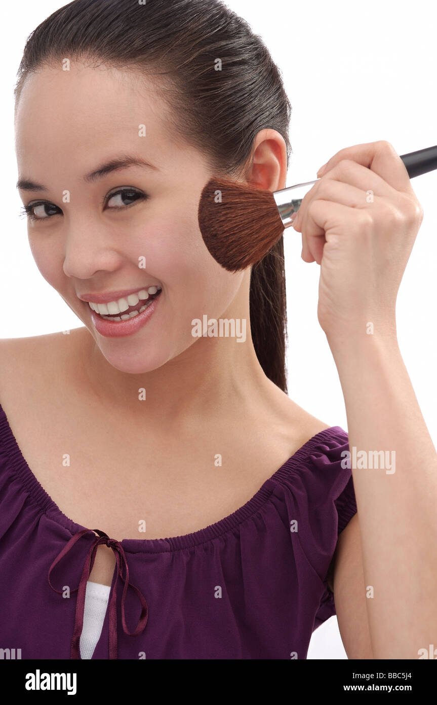 Young woman applying make-up Stock Photo - Alamy