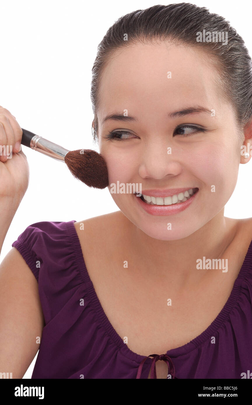 Young woman applying make-up Stock Photo - Alamy