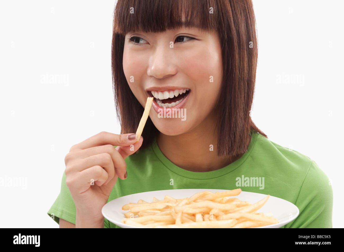 Young woman eating French fries Stock Photo - Alamy