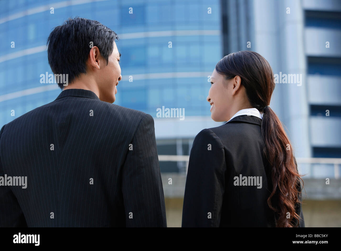 Executives standing side by side, talking, rear view Stock Photo - Alamy