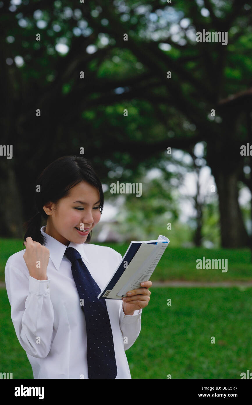 Young woman in school uniform, reading a book Stock Photo - Alamy