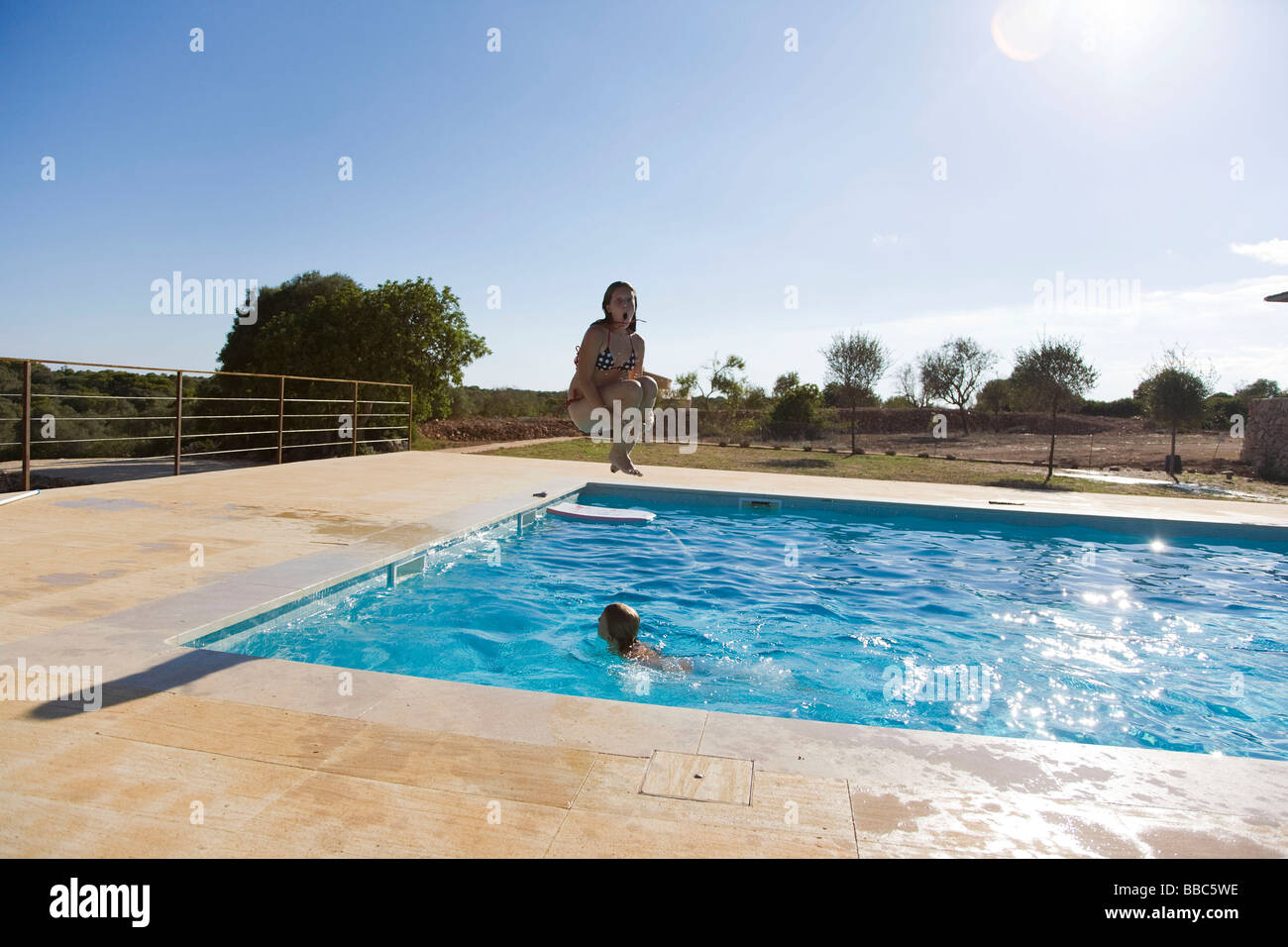 Girl jumping into pool Stock Photo - Alamy
