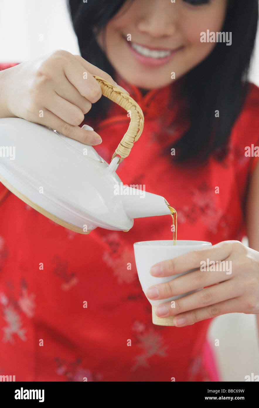Woman pouring tea from teapot Stock Photo - Alamy