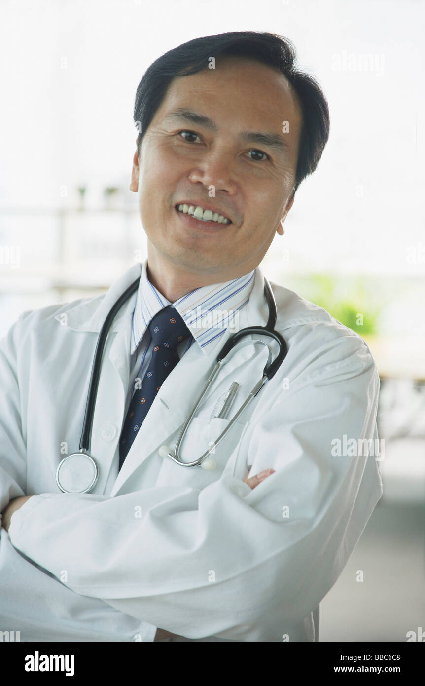 Doctor smiling at camera, arms crossed Stock Photo - Alamy