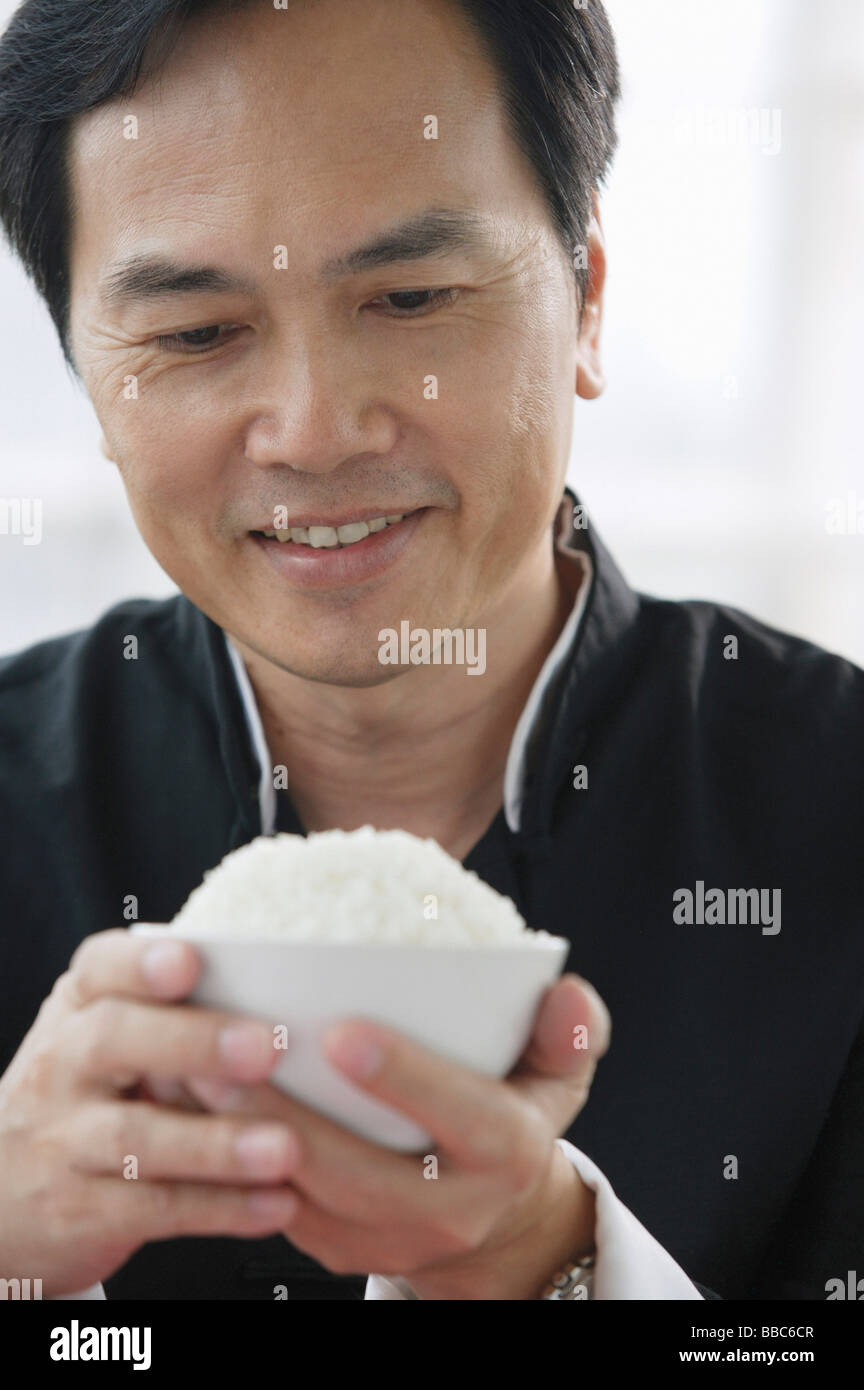 Man looking at bowl of rice in his hands Stock Photo - Alamy