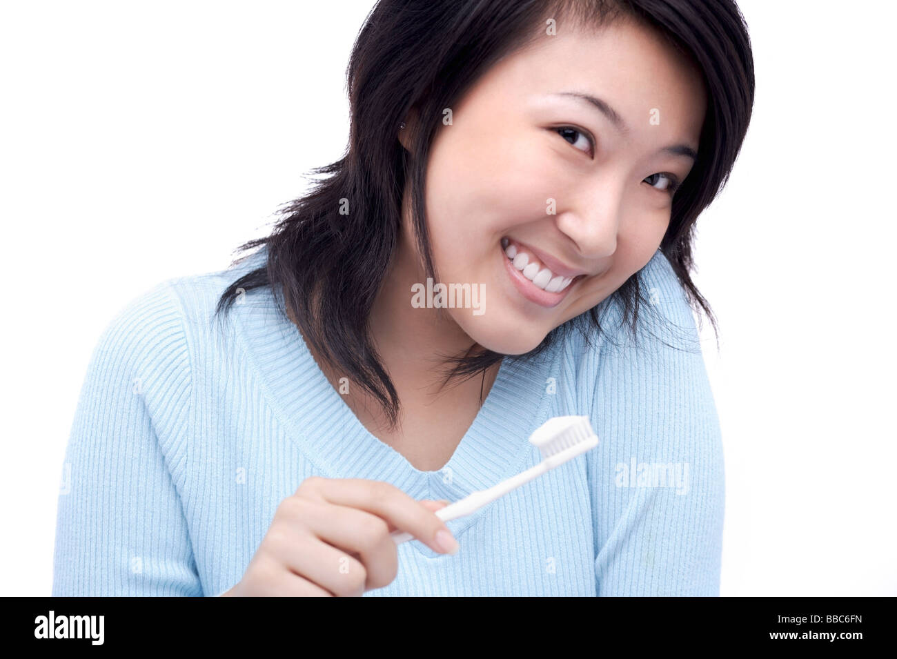Young woman with toothbrush, smiling at camera Stock Photo - Alamy