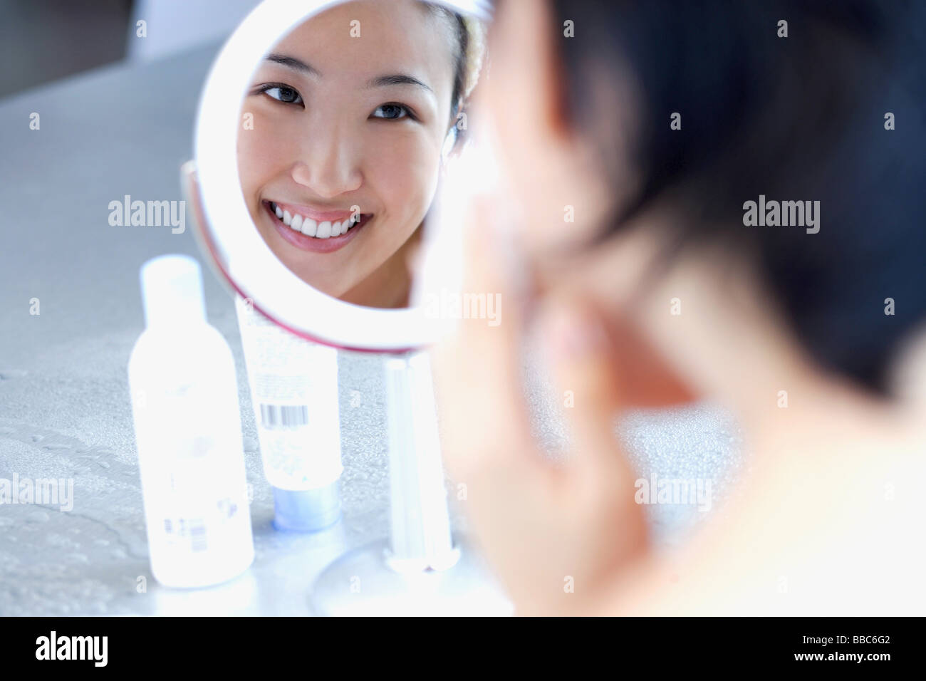 Young woman looking in mirror, over the shoulder view Stock Photo - Alamy