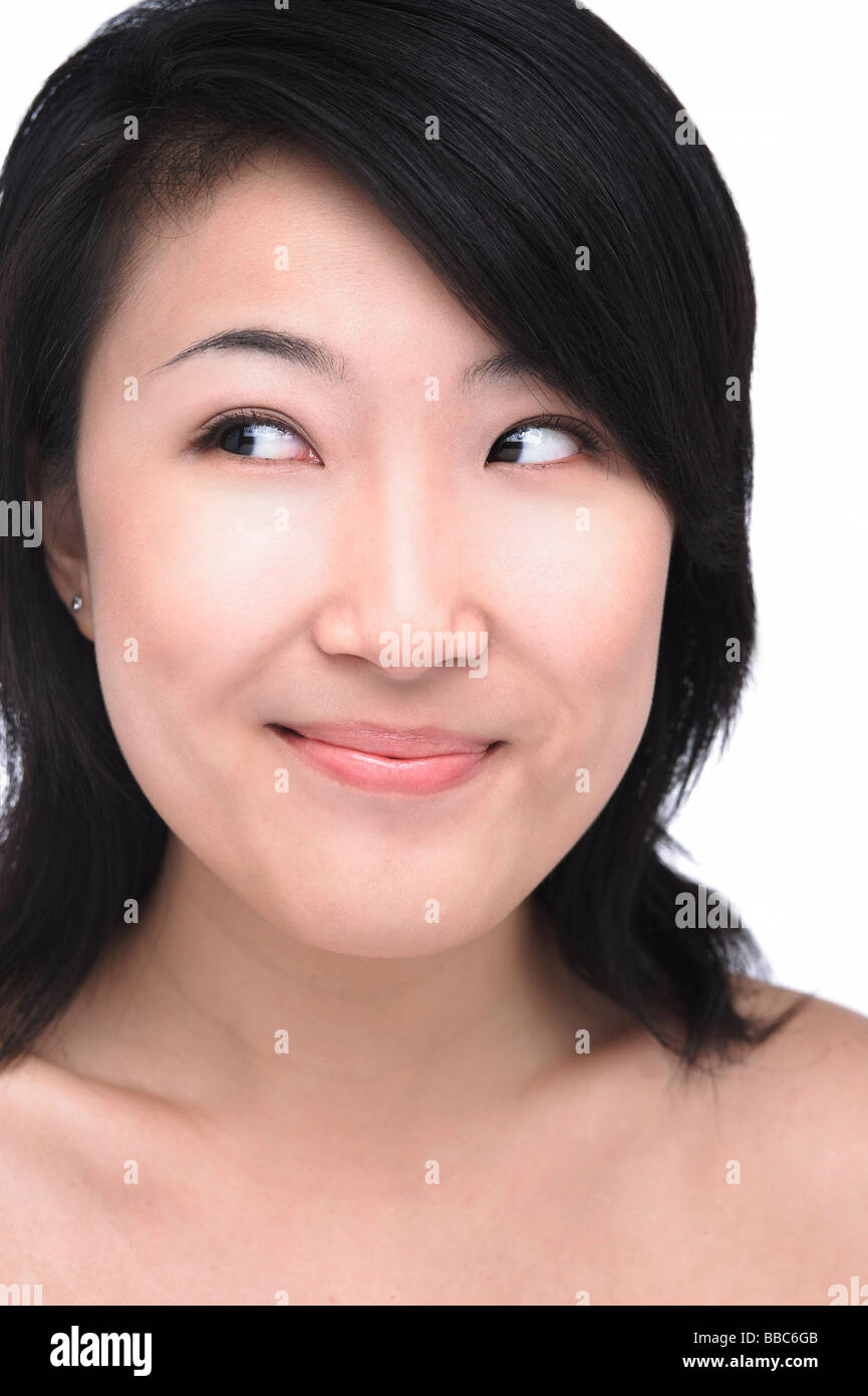 Young woman smiling, sideways glance Stock Photo - Alamy