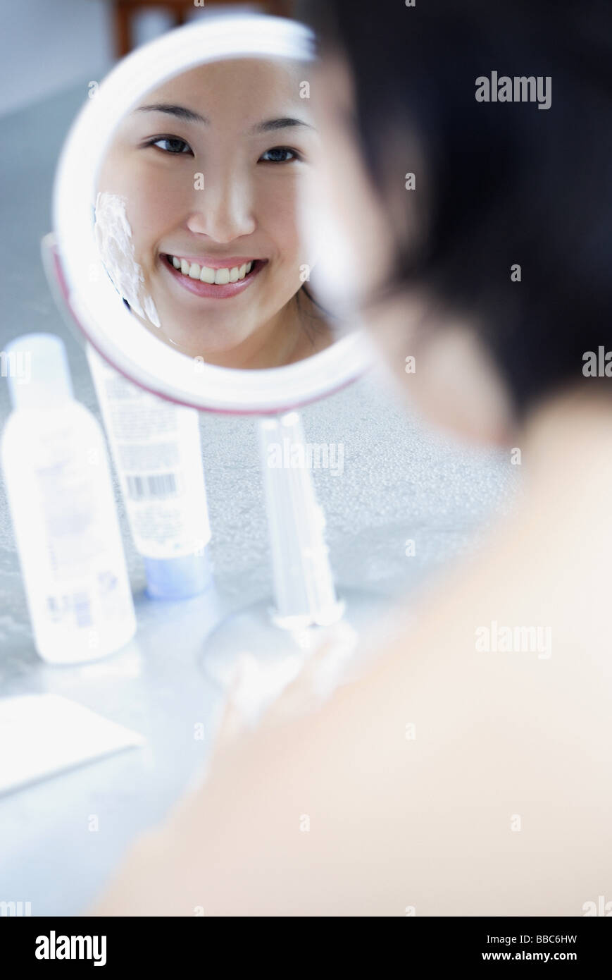 Young woman looking in mirror, over the shoulder view Stock Photo - Alamy