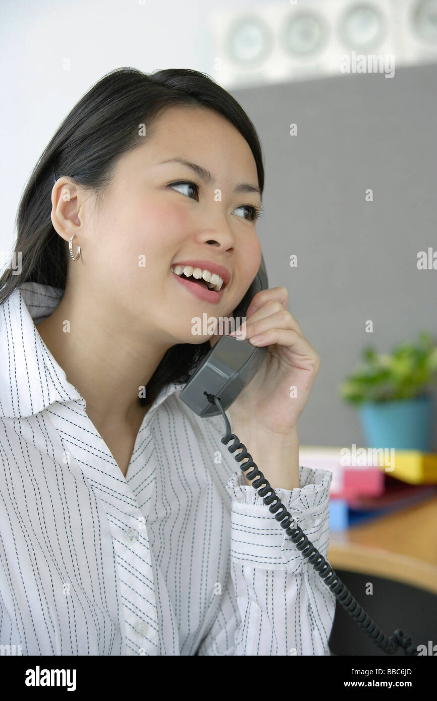 Young woman using telephone Stock Photo - Alamy