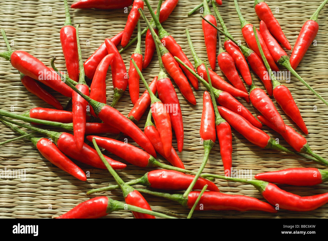 Still life of chilies against woven mat Stock Photo - Alamy
