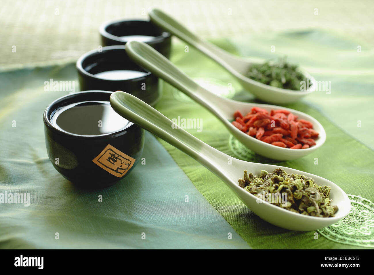 Asian still life with spoons balancing on teacups Stock Photo - Alamy