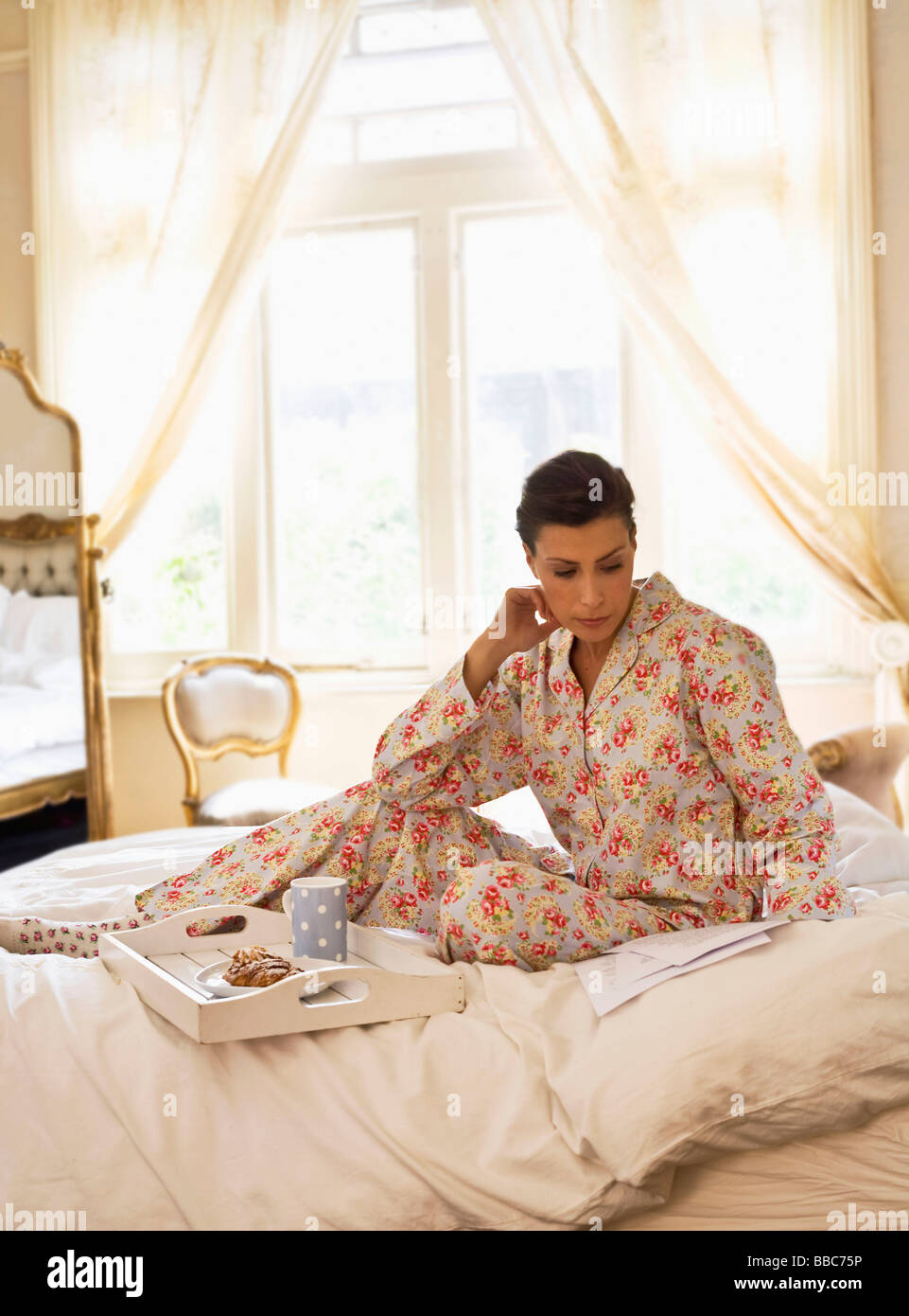 Young woman in bed wearing pyjamas Stock Photo - Alamy