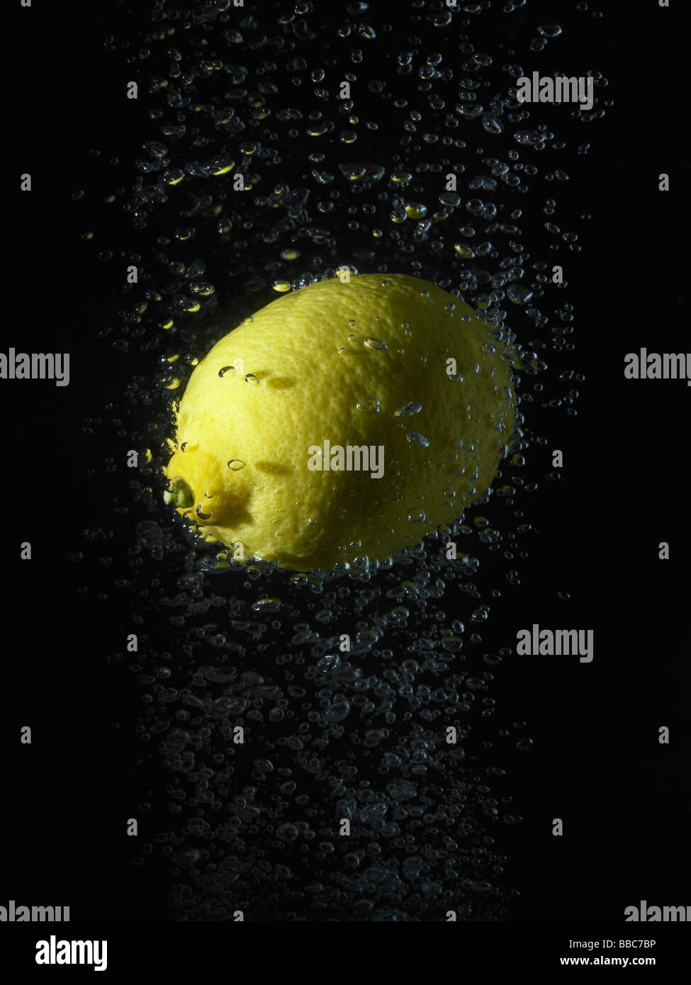 Lemon in bubbles, black background Stock Photo - Alamy
