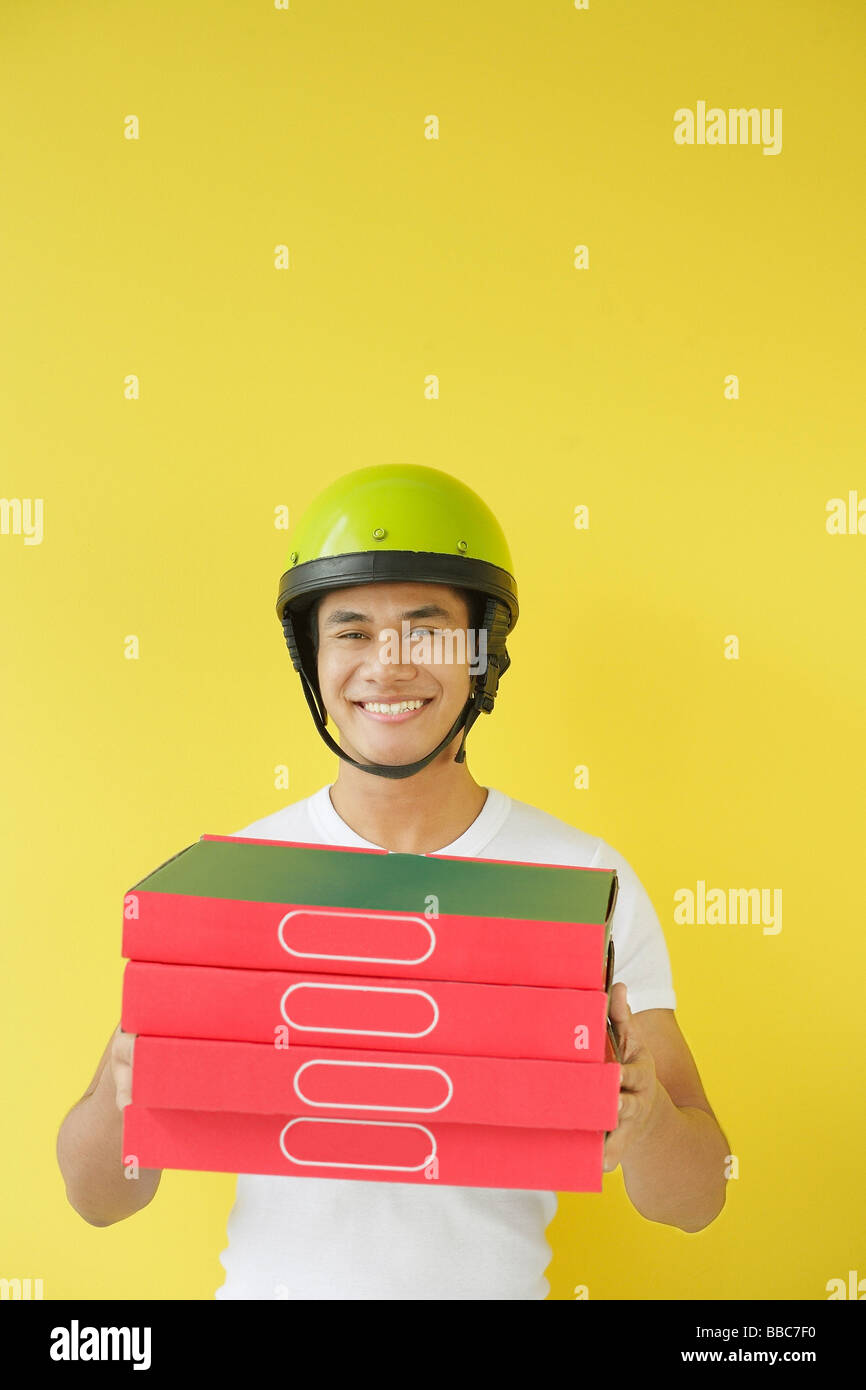 Pizza delivery person carrying a stack of pizza boxes Stock Photo - Alamy