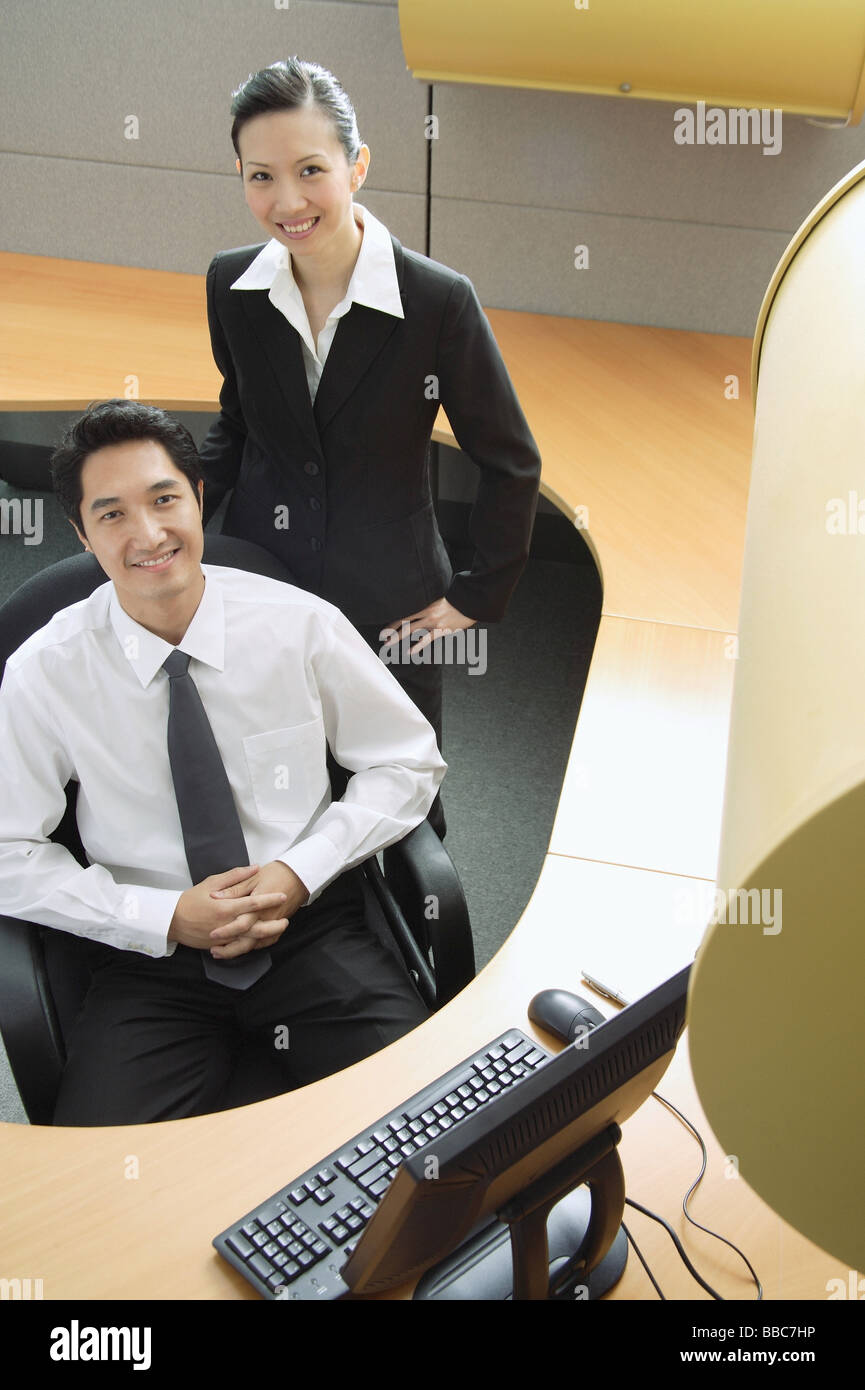 Businessman and woman in office cubicle, smiling at camera Stock Photo ...
