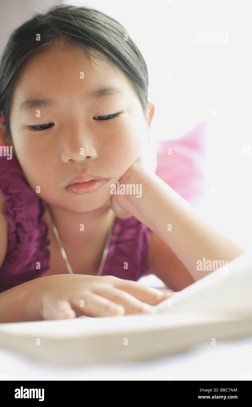 Girl reading book, hand on chin Stock Photo - Alamy