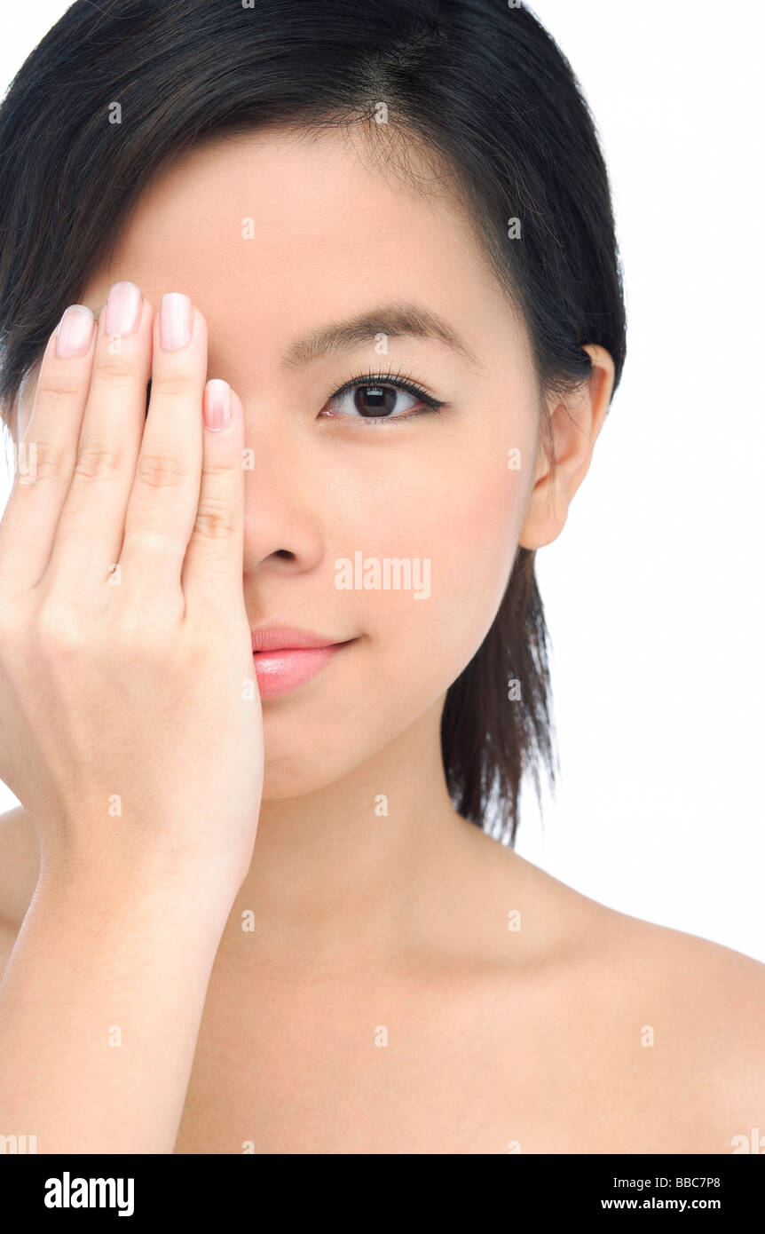 Young woman covering half her face with her hand Stock Photo - Alamy