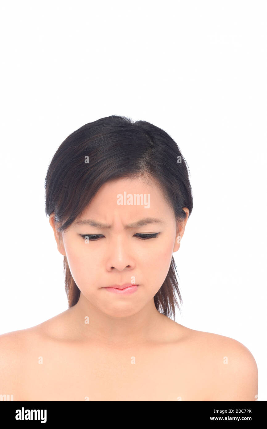 Young woman frowning, looking down Stock Photo - Alamy