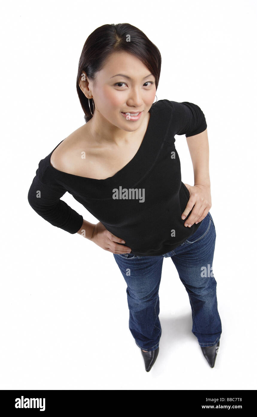 Young woman standing with hands on hip looking at camera Stock Photo ...