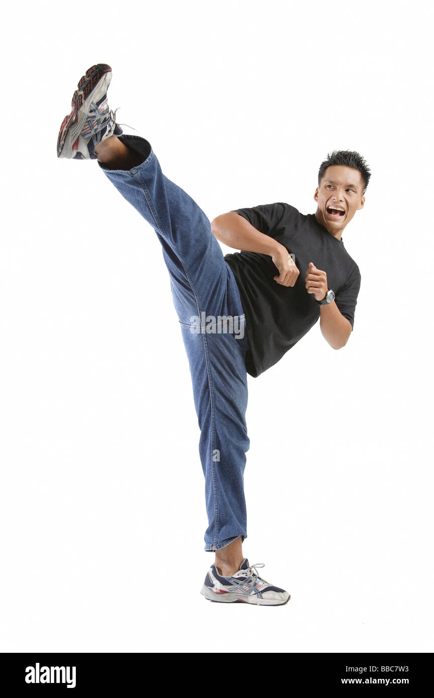 Young man kicking Stock Photo - Alamy