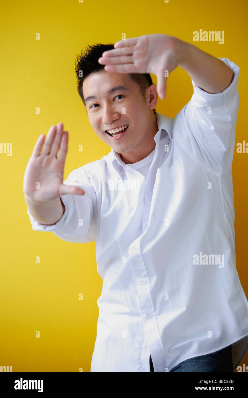 Man smiling at camera, making finger frame Stock Photo - Alamy