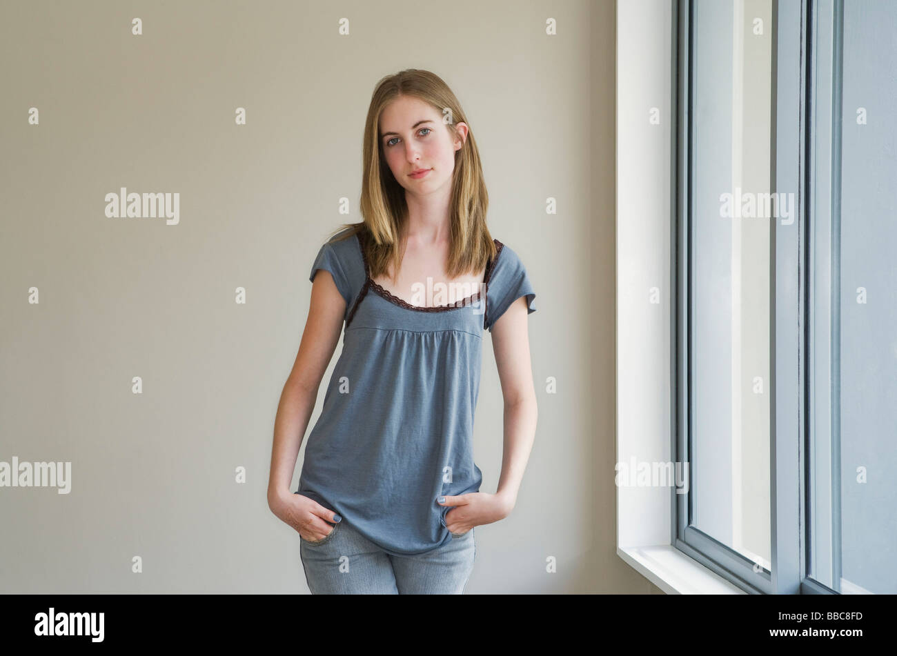 Woman standing near window Stock Photo - Alamy