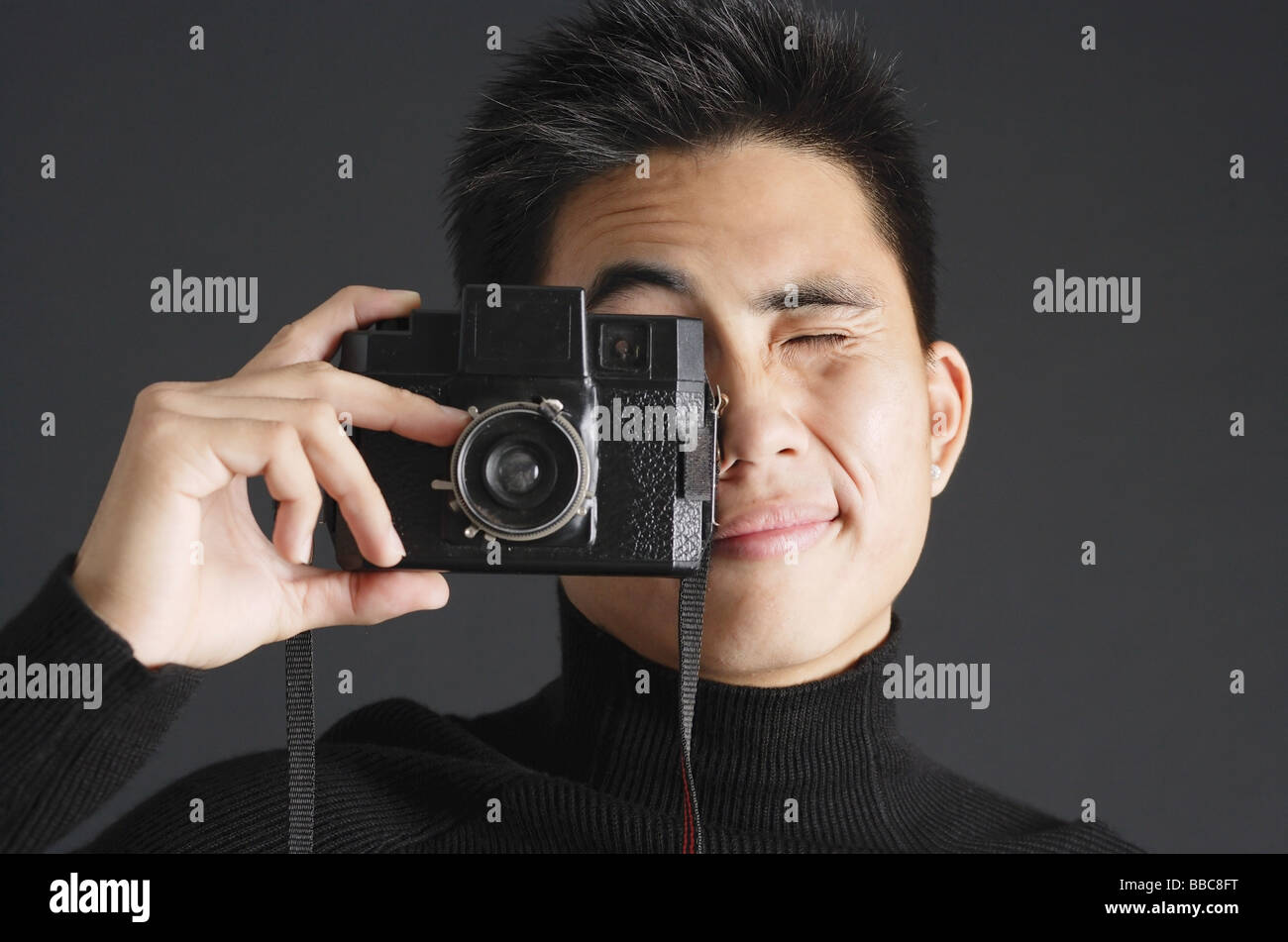 Young man looking through camera Stock Photo - Alamy