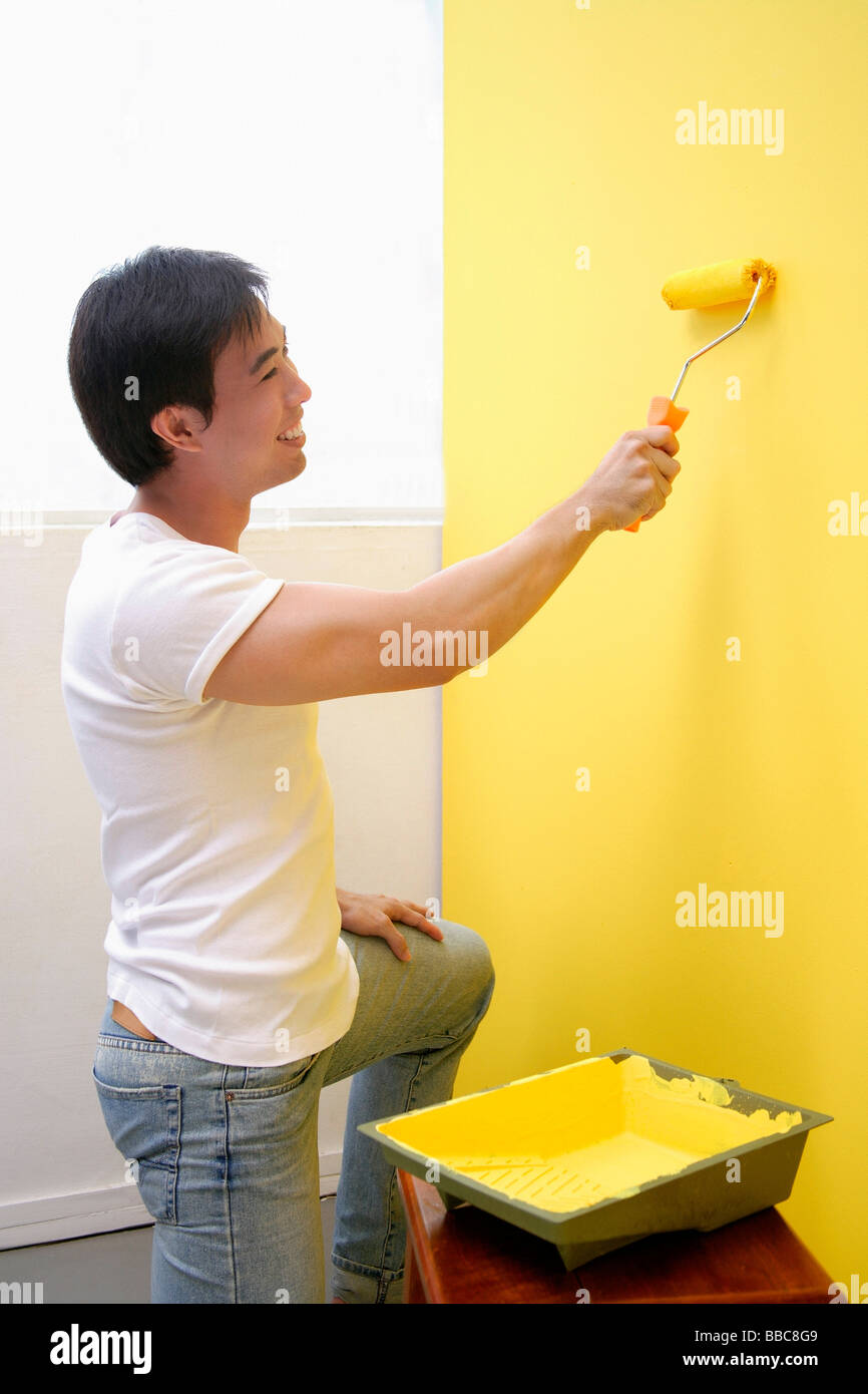 Man painting wall Stock Photo - Alamy