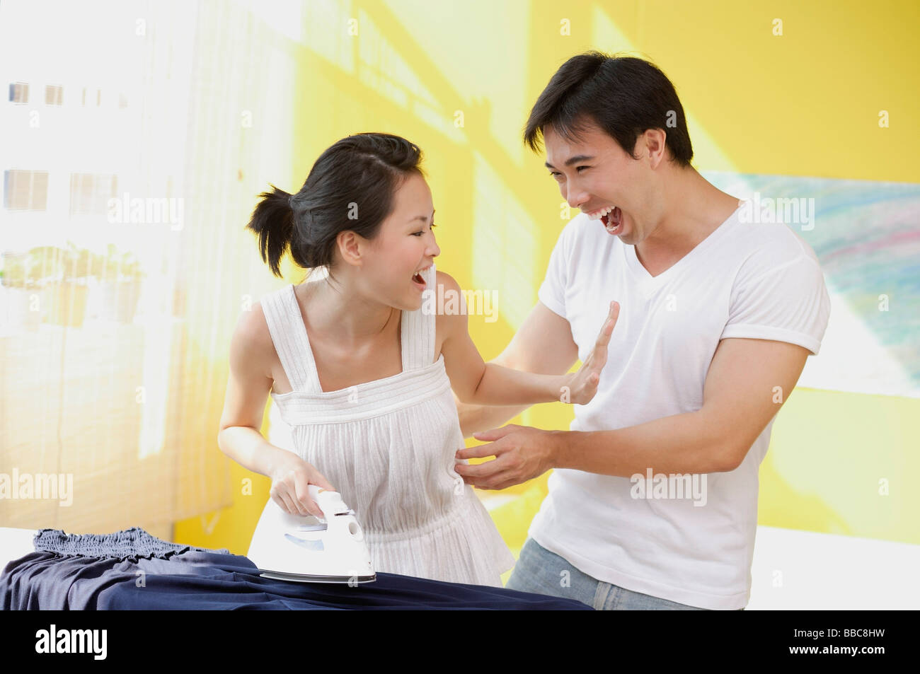 Woman with iron pushing man away Stock Photo - Alamy