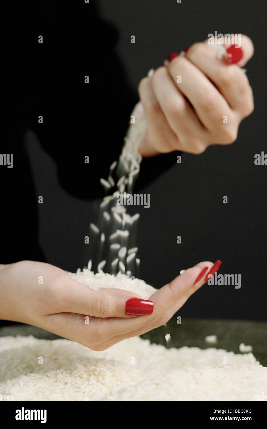Woman sifting rice between fingers Stock Photo - Alamy