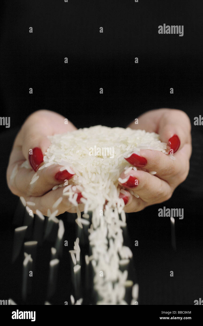 Woman holding rice in cupped hands Stock Photo - Alamy