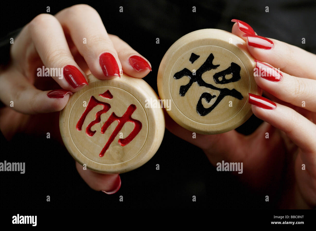 Womans hands holding Chinese chess pieces Stock Photo - Alamy