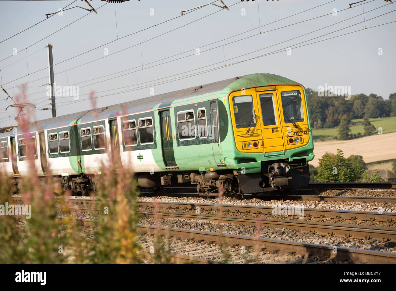 Passenger train class 319 in Southern livery speeding through the ...