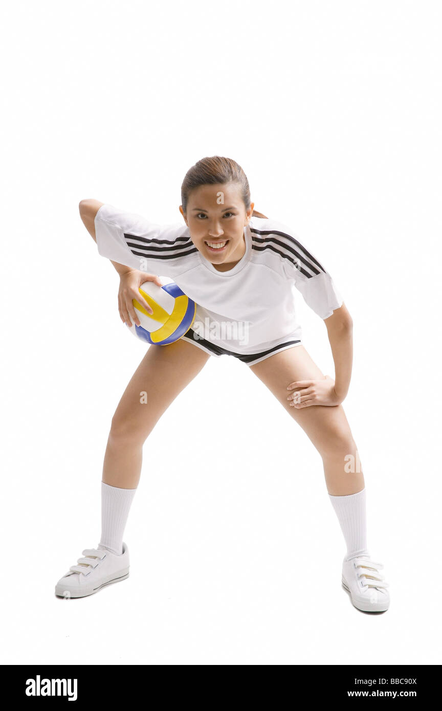 Young woman bending and holding volleyball Stock Photo - Alamy
