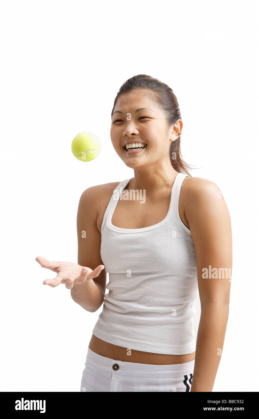 Young woman tossing tennis ball Stock Photo - Alamy