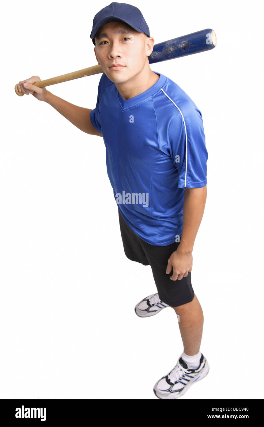 Young man holding baseball bat, looking up at camera Stock Photo - Alamy