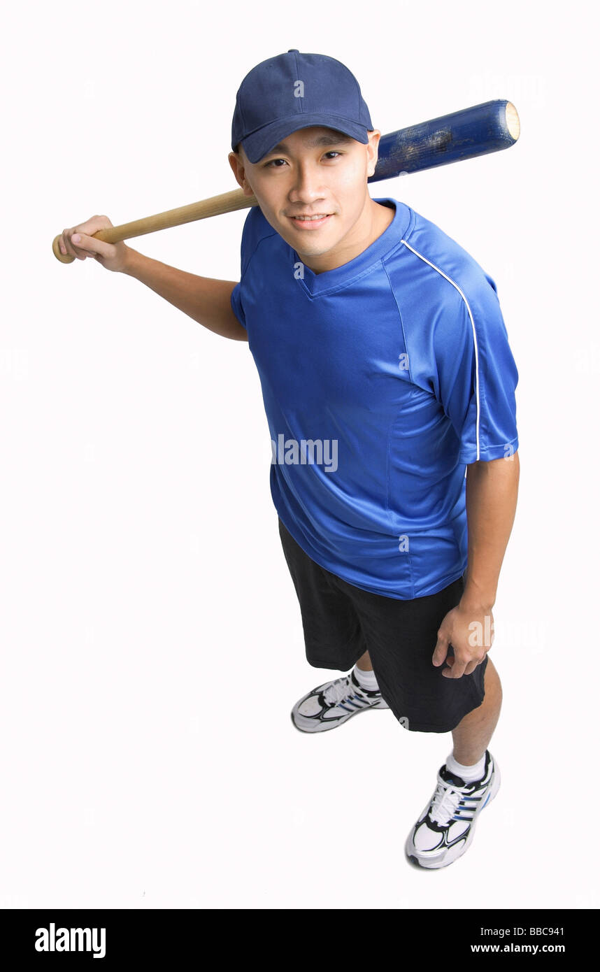 Young man holding baseball bat, smiling up at camera Stock Photo - Alamy