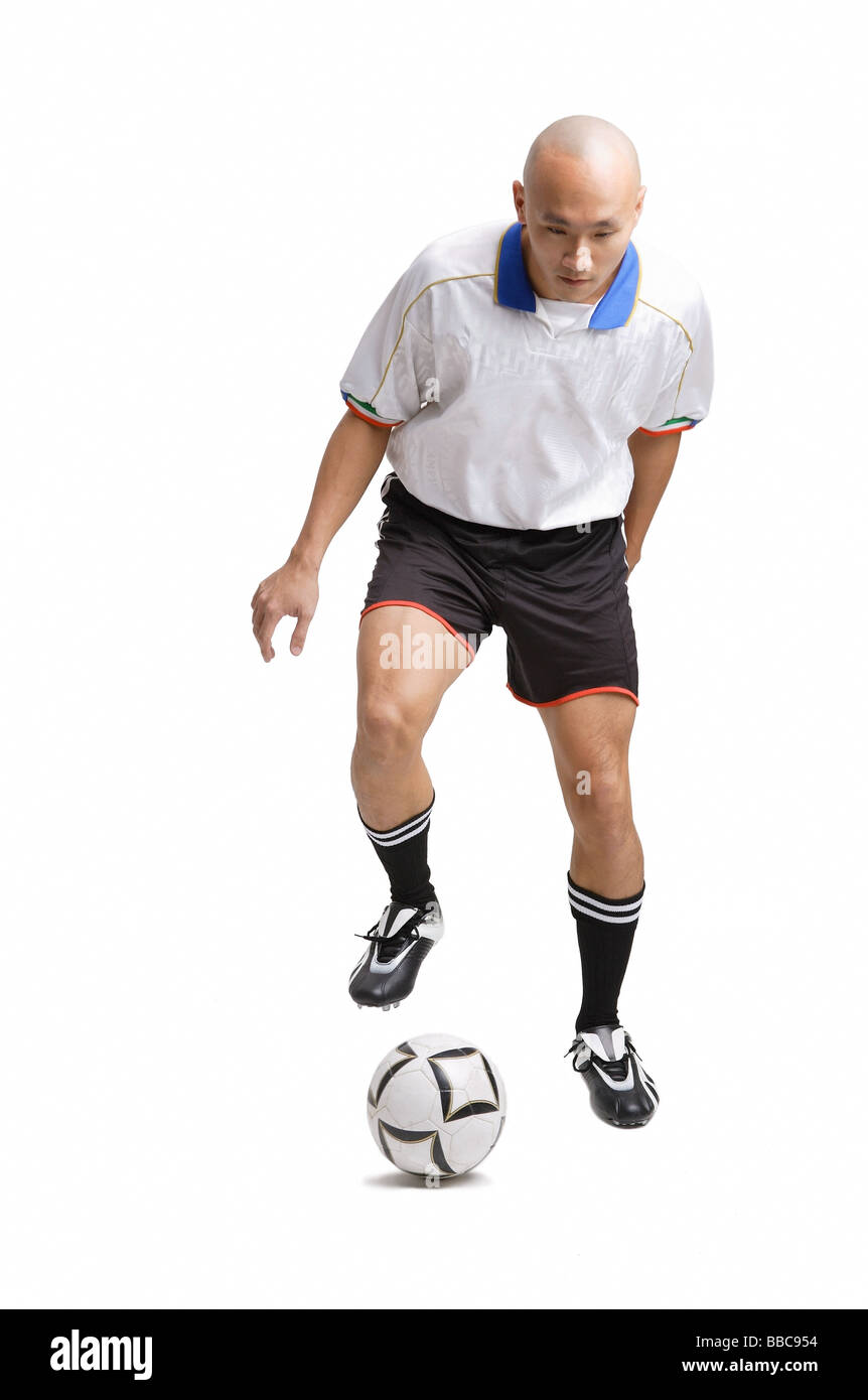Young man playing with soccer ball Stock Photo - Alamy