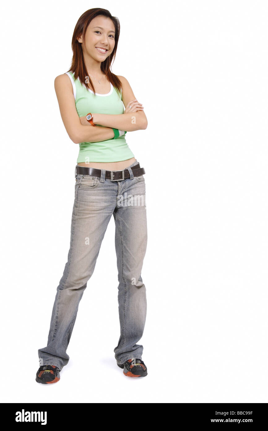 Young Woman In Tank Top And Jeans Arms Crossed Smiling At Camera