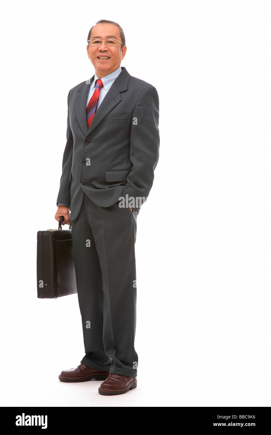 Businessman standing with briefcase, portrait Stock Photo - Alamy