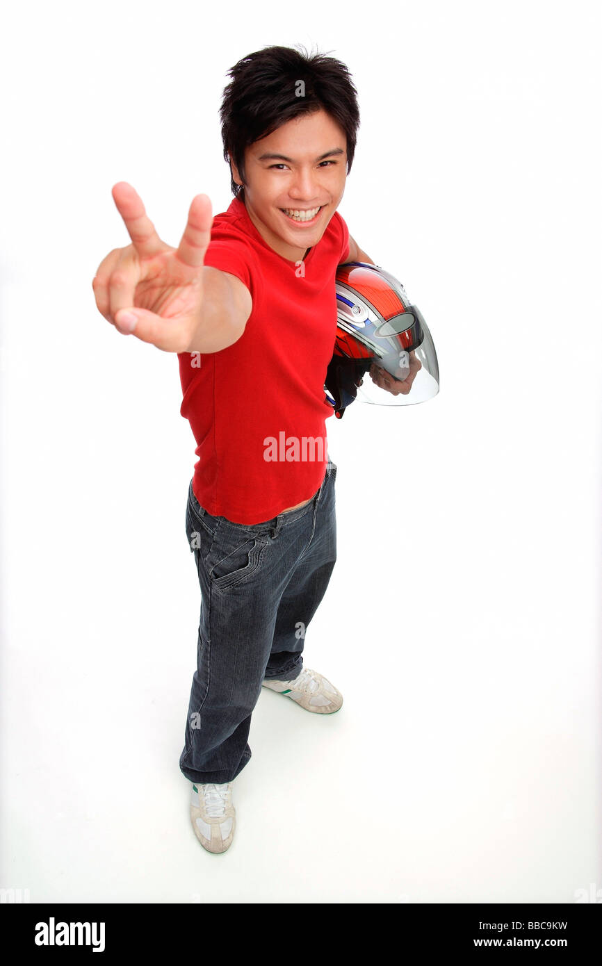 Young man with motorcycle helmet, making peace sign Stock Photo - Alamy