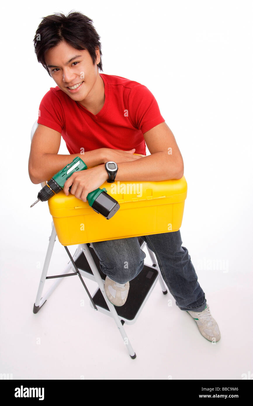 Man sitting on stepladder, holding toolbox and tools, portraits Stock ...