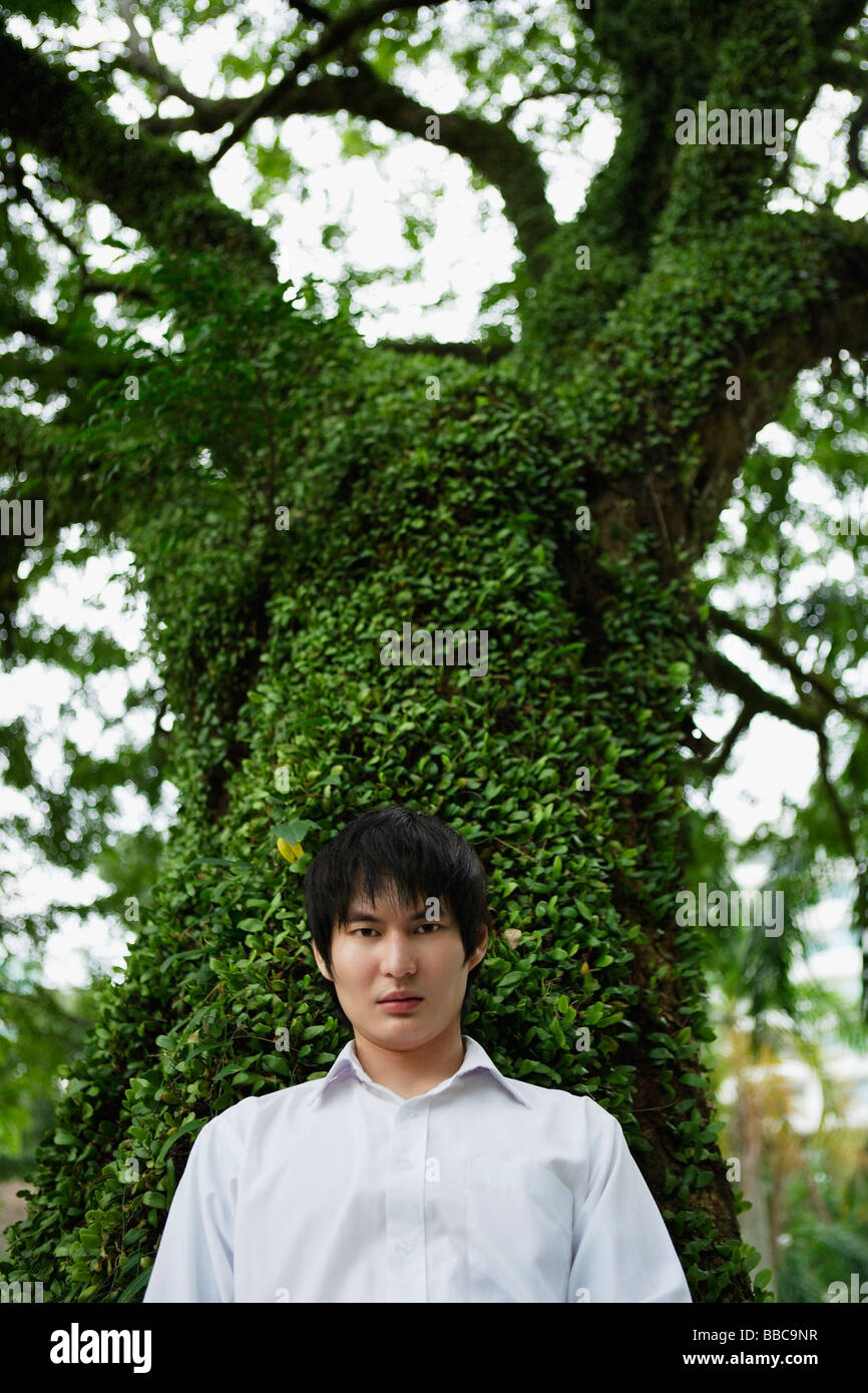 young man standing in front of tree Stock Photo - Alamy