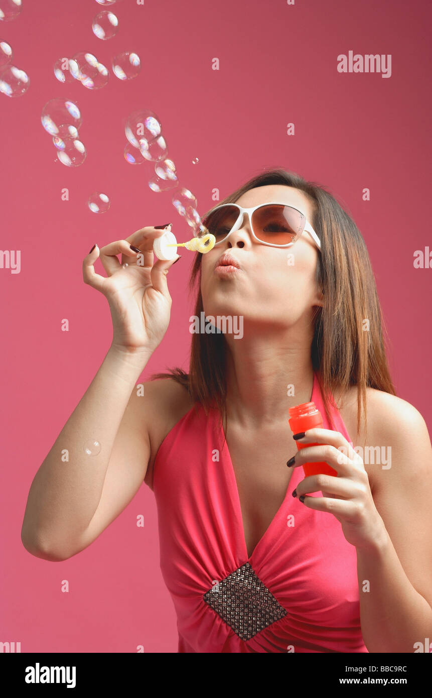 Woman dressed in pink, blowing bubbles Stock Photo - Alamy