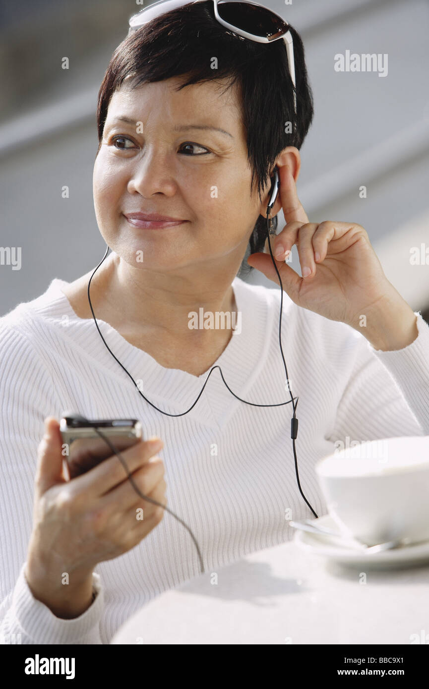 Woman listening to music from an MP3 player Stock Photo - Alamy
