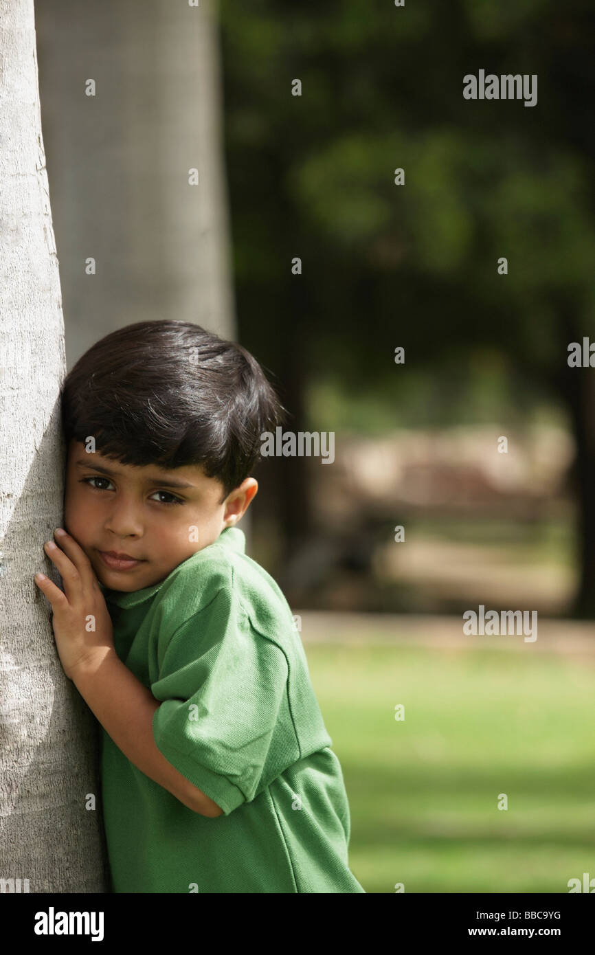 Little boy hugging tree trunk Stock Photo - Alamy