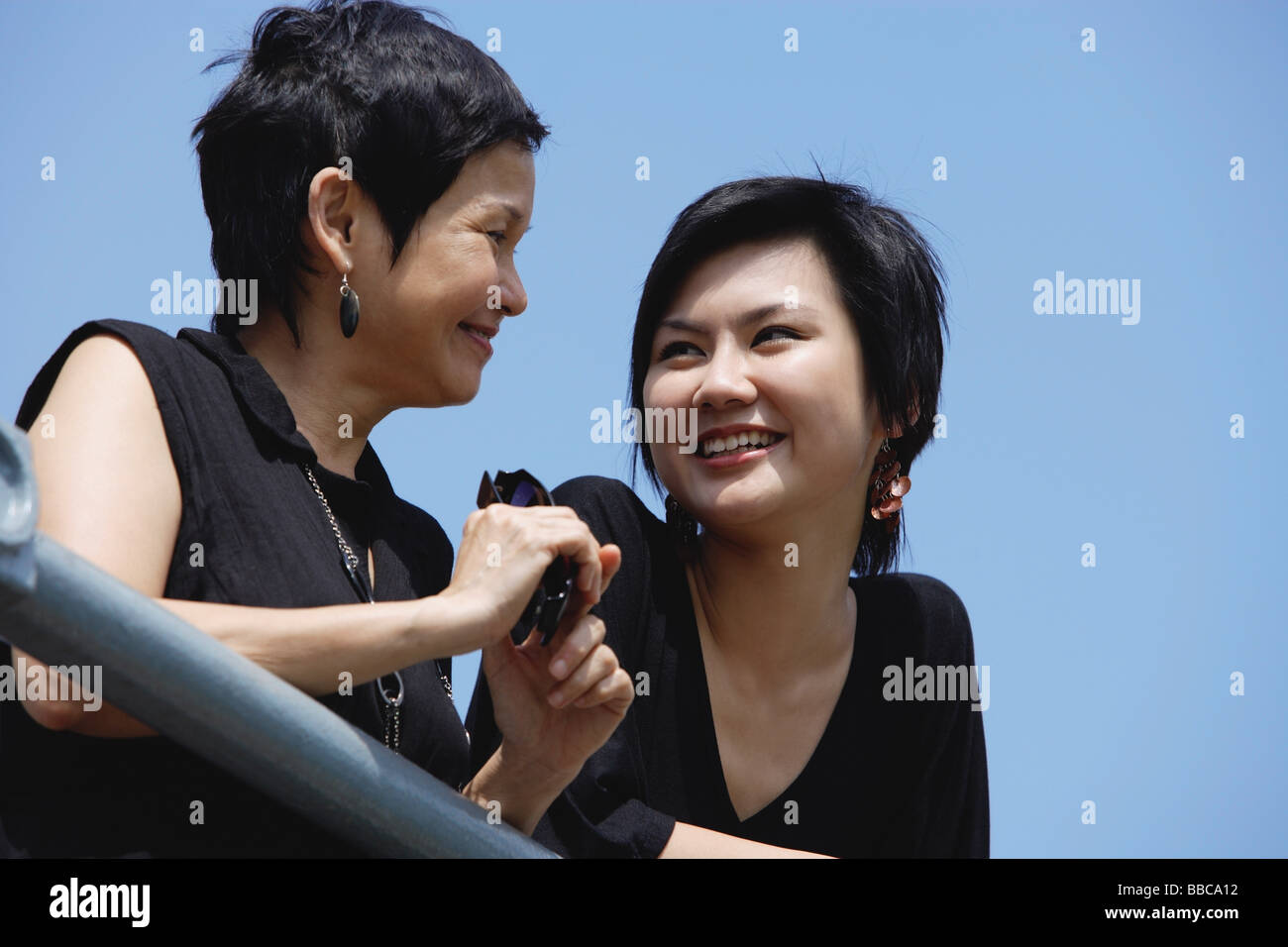 Women side by side, smiling, looking away Stock Photo - Alamy
